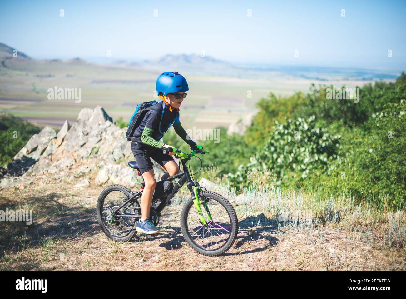 Happy kid boy of 8 years having fun in summer park with a bicycle on ...