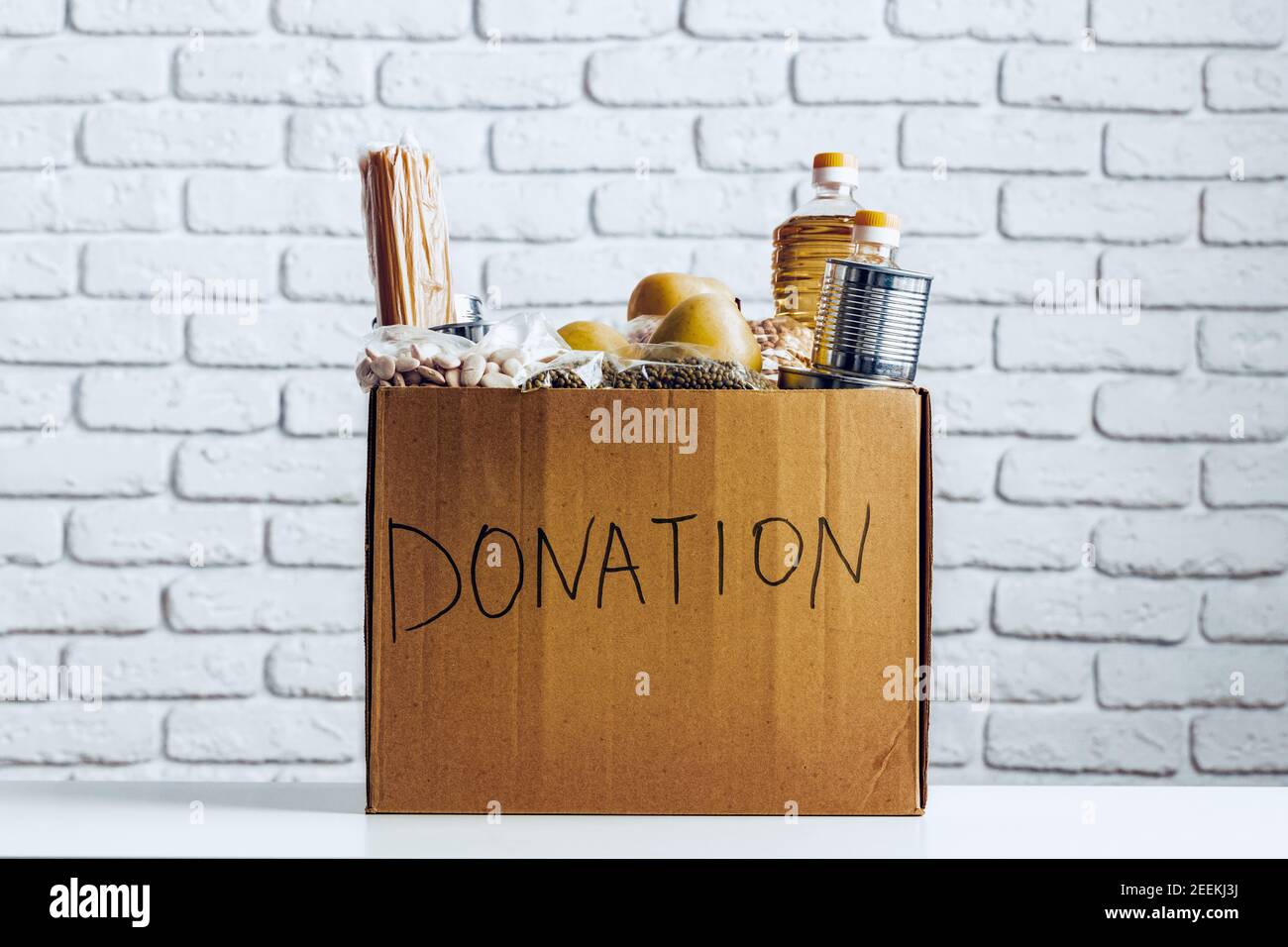 Donations box with canned food on the table Stock Photo - Alamy