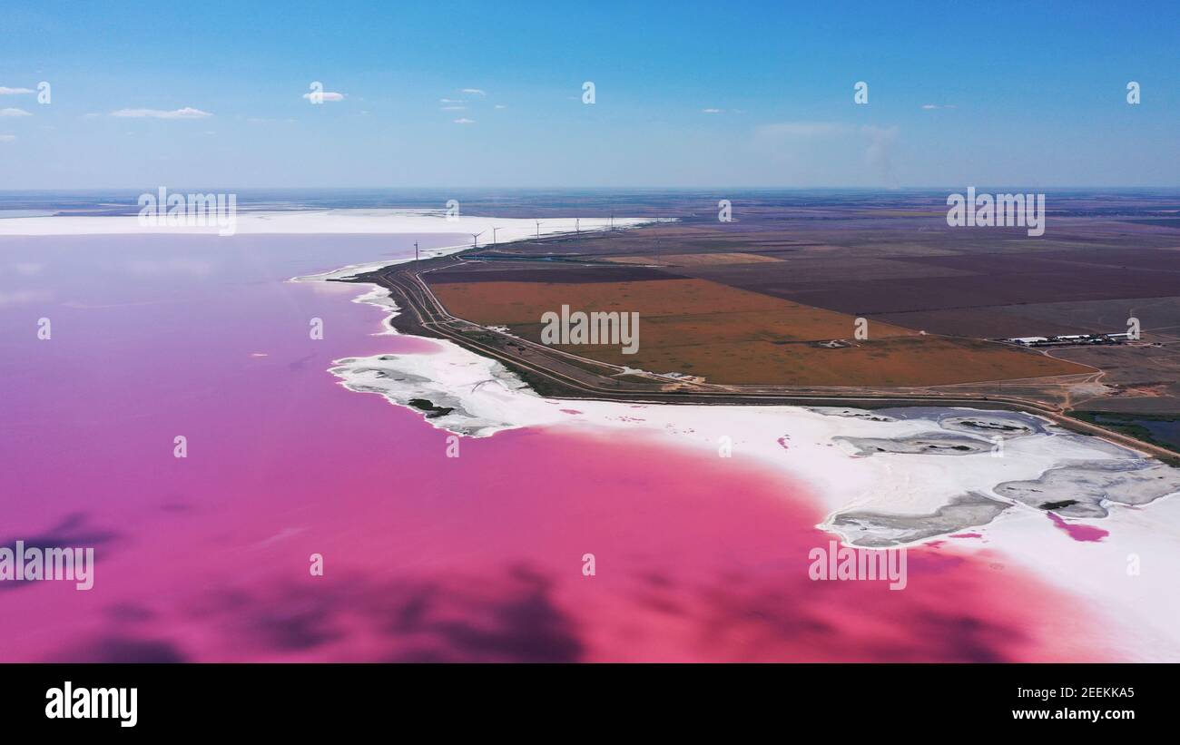 aerial view to pink lake with salt shore with little islands with copy ...
