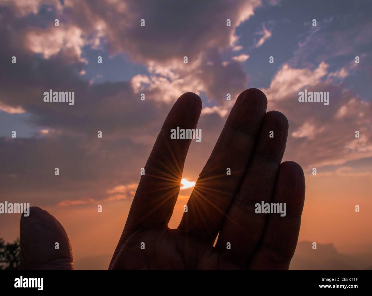 Sun-rays piercing through dark clouds and fingers at dusk Stock Photo ...
