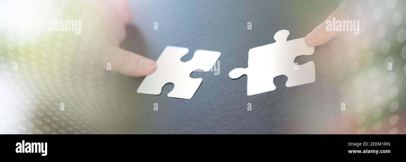 Hands joining two puzzle pieces, teamwork concept; panoramic banner ...