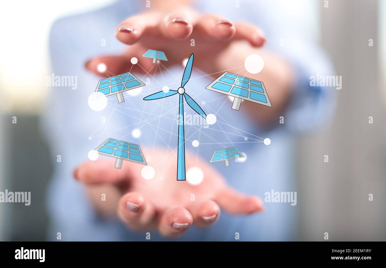 Green energy concept between hands of a woman in background Stock Photo ...