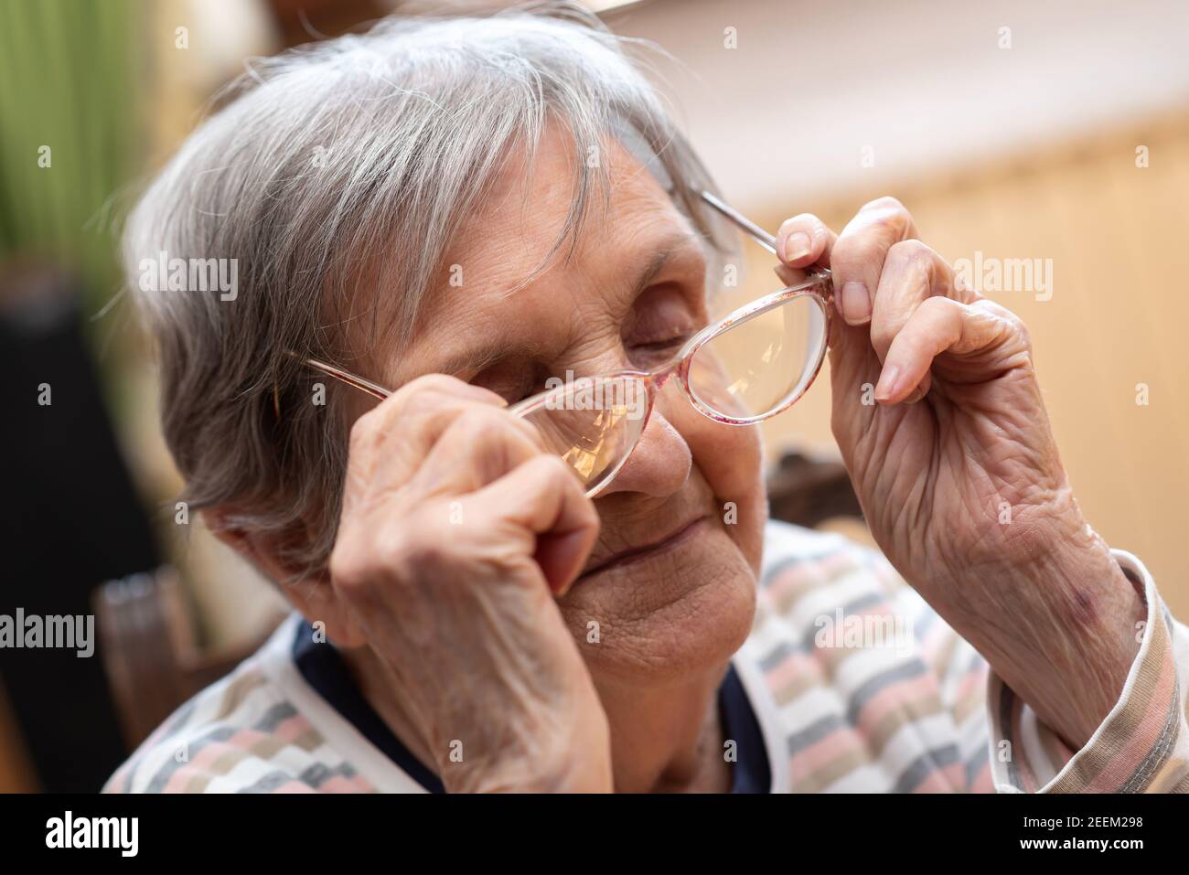 Senior woman putting on glasses hi-res stock photography and images - Alamy