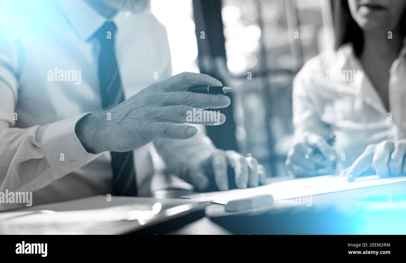 Senior manager working with executive assistant in office; light effect ...