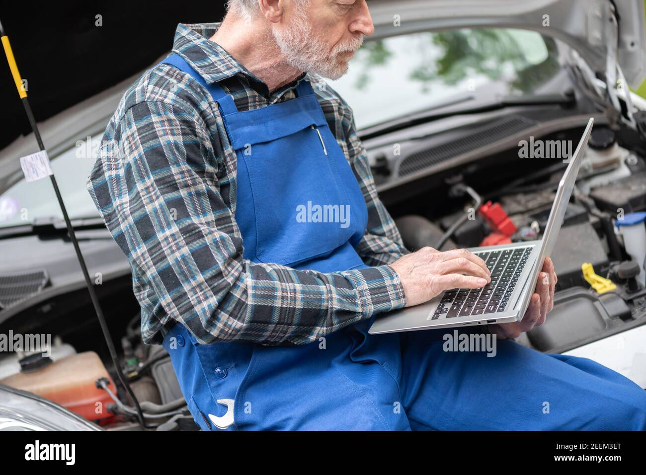 Car mechanic using laptop for checking car engine Stock Photo - Alamy