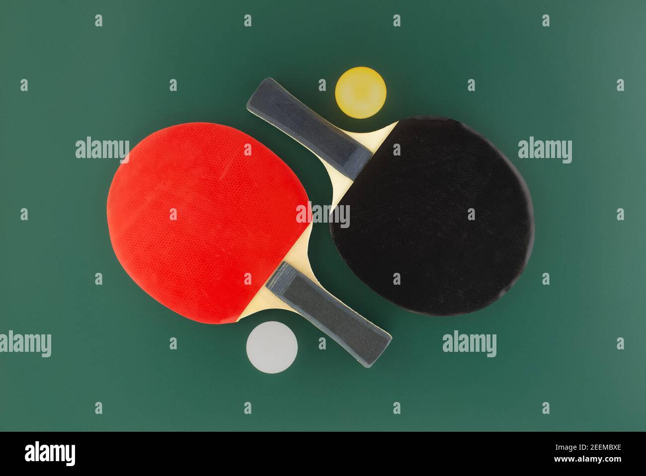 Red and black table tennis racks with a white and an yellow ping pong ...