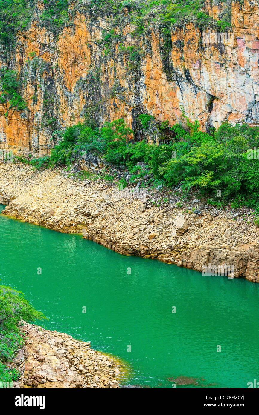Lake with natural green water surrounded by wall of sedimentary rocks ...