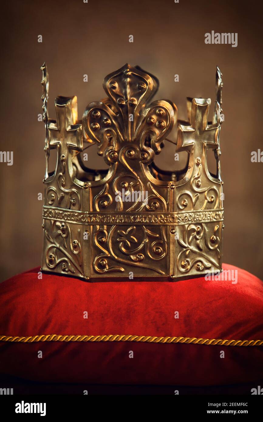 Gold crown of the King placed on a red velvet cushion. The image can be ...