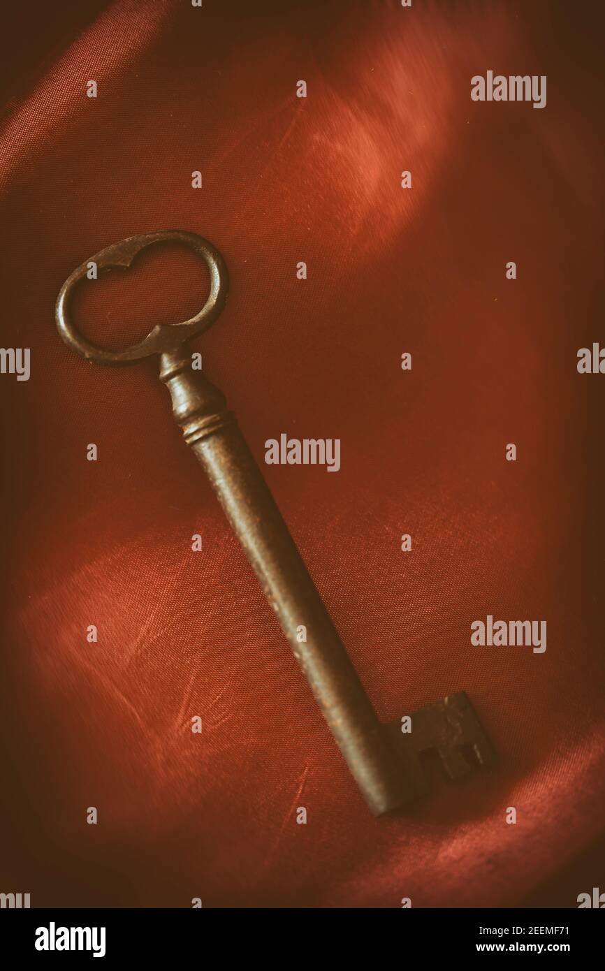 Ancient medieval wrought iron key on red background Stock Photo - Alamy