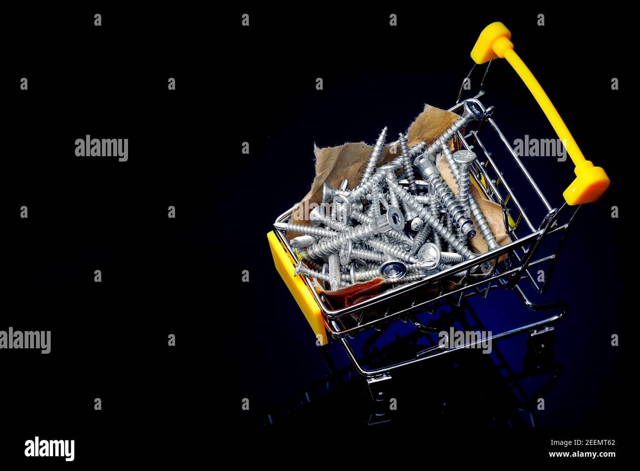 Steel screws lie on craft paper in a small shopping cart. Advertising ...