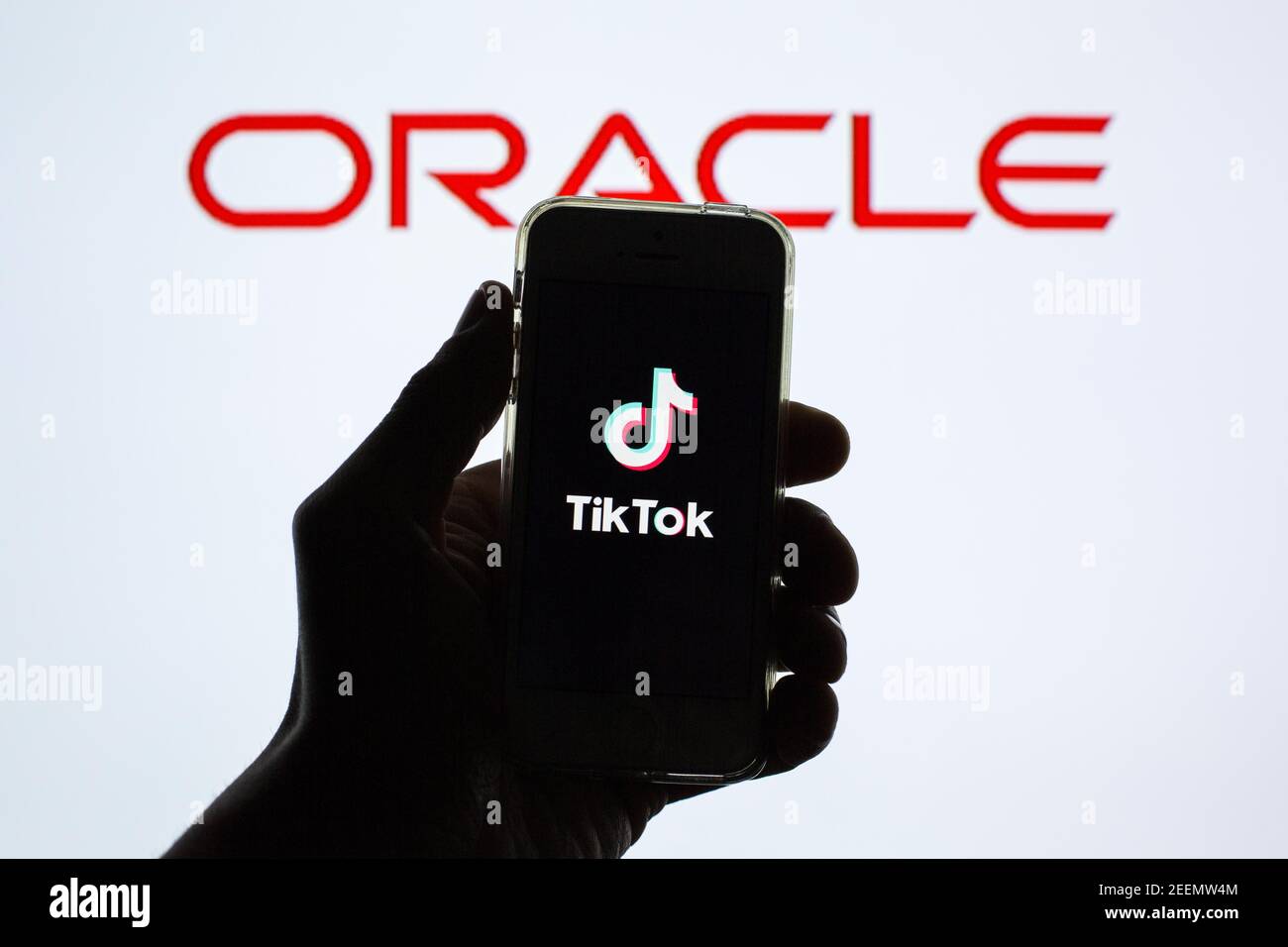 In this photo illustration, a Tik Tok app seen displayed on a smartphone with the Oracle logo in ...
