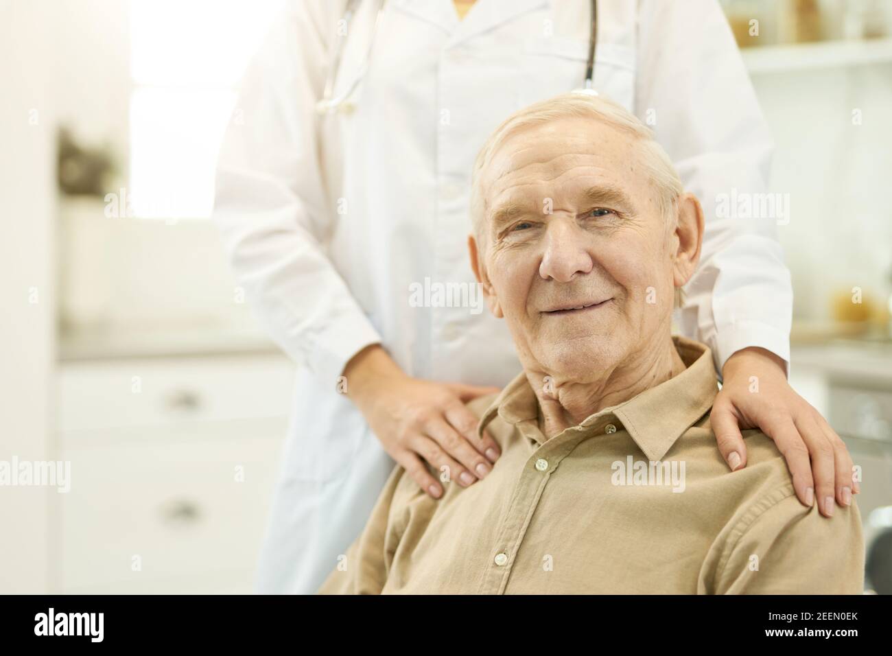 Cropped photo of a happy senior citizen sitting down and doctor in ...