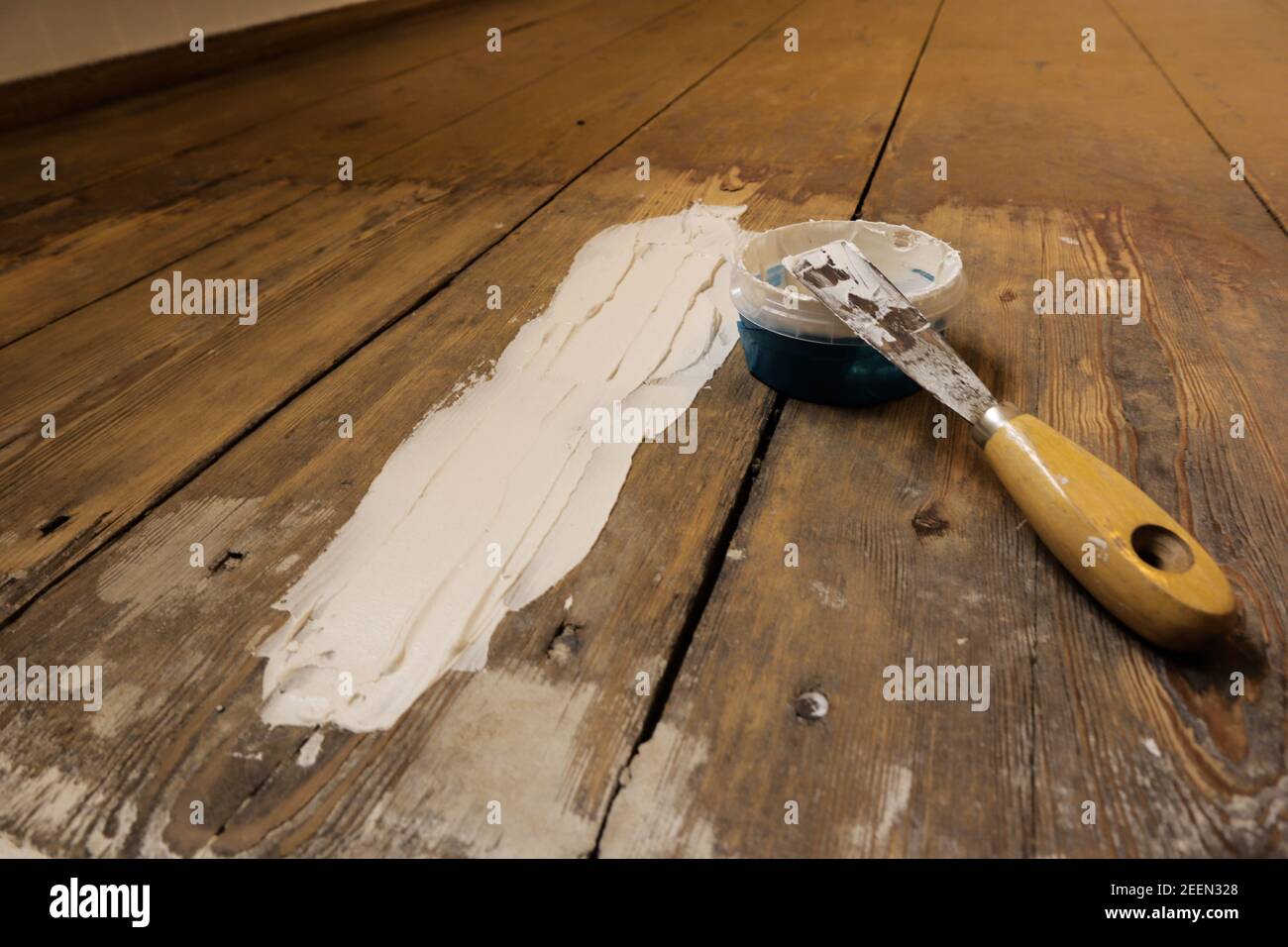 Applying putty on the old wooden floor, refurbishing floor Stock Photo ...