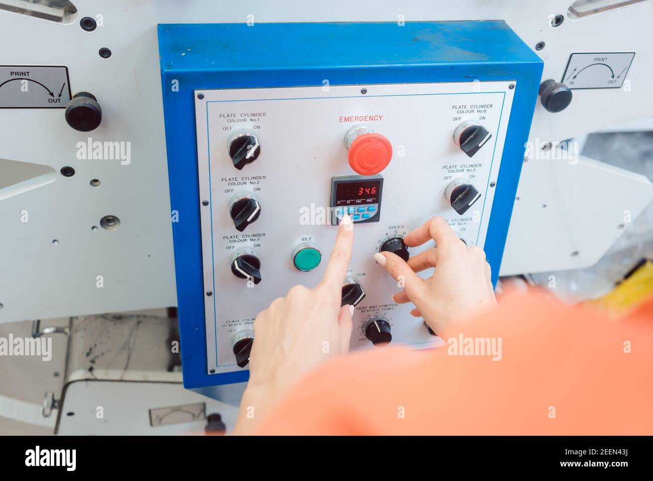 Woman pressing start button on label printing machine Stock Photo - Alamy