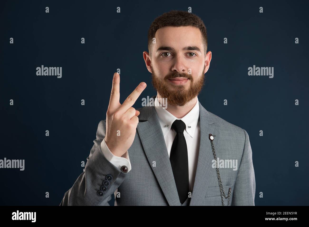 Happy businessman showing the number two wearing a black tie and grey ...