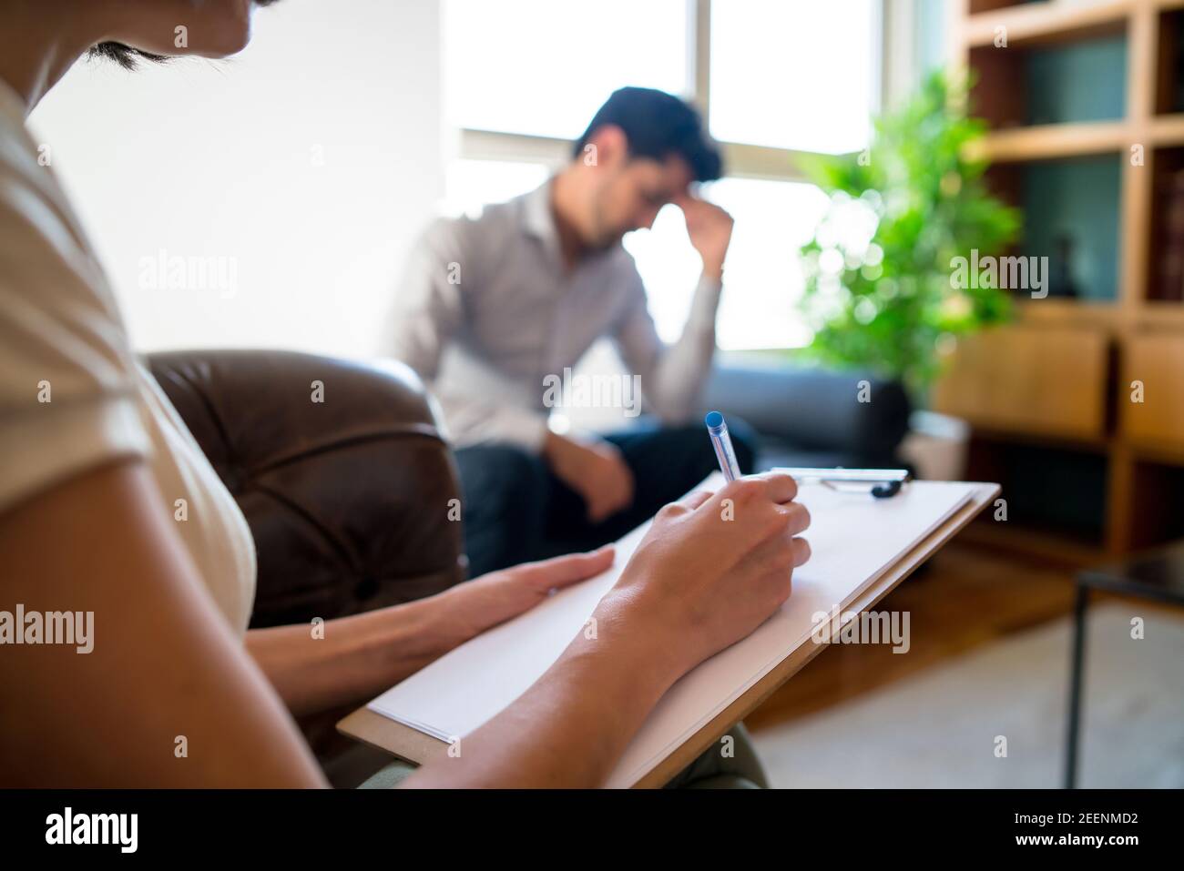 Psychologist taking notes during therapy session Stock Photo - Alamy