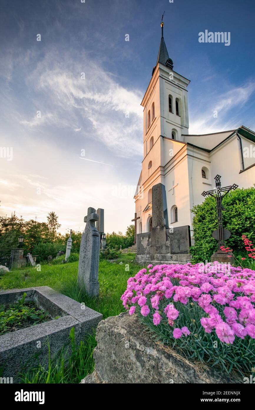 Small old christian church with a graveyard in front in the golden hour ...
