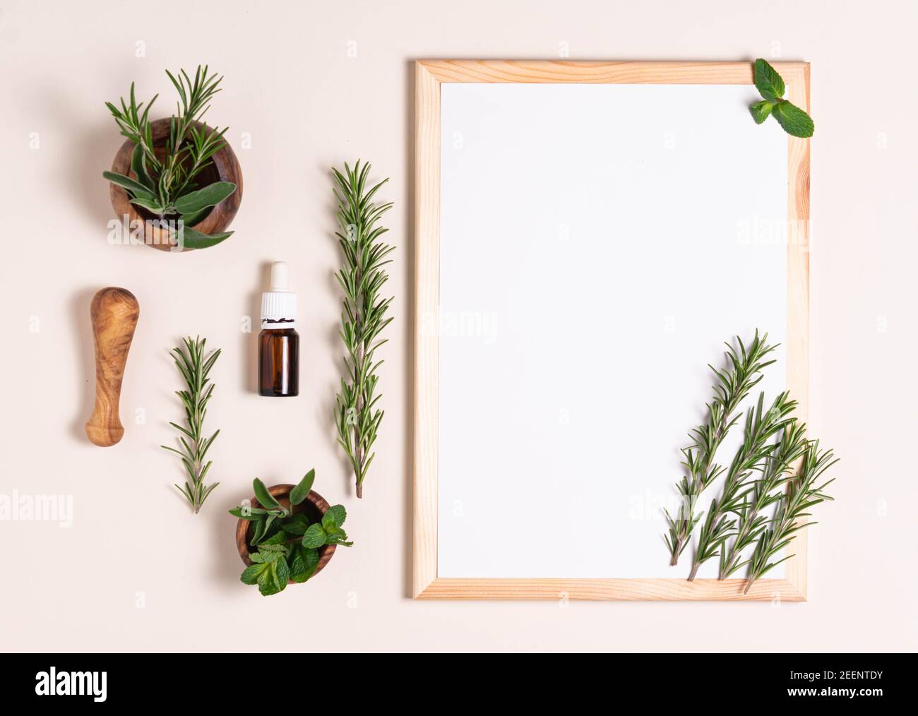 top view, white sheet of paper with rosemary, essential oil and mortar ...