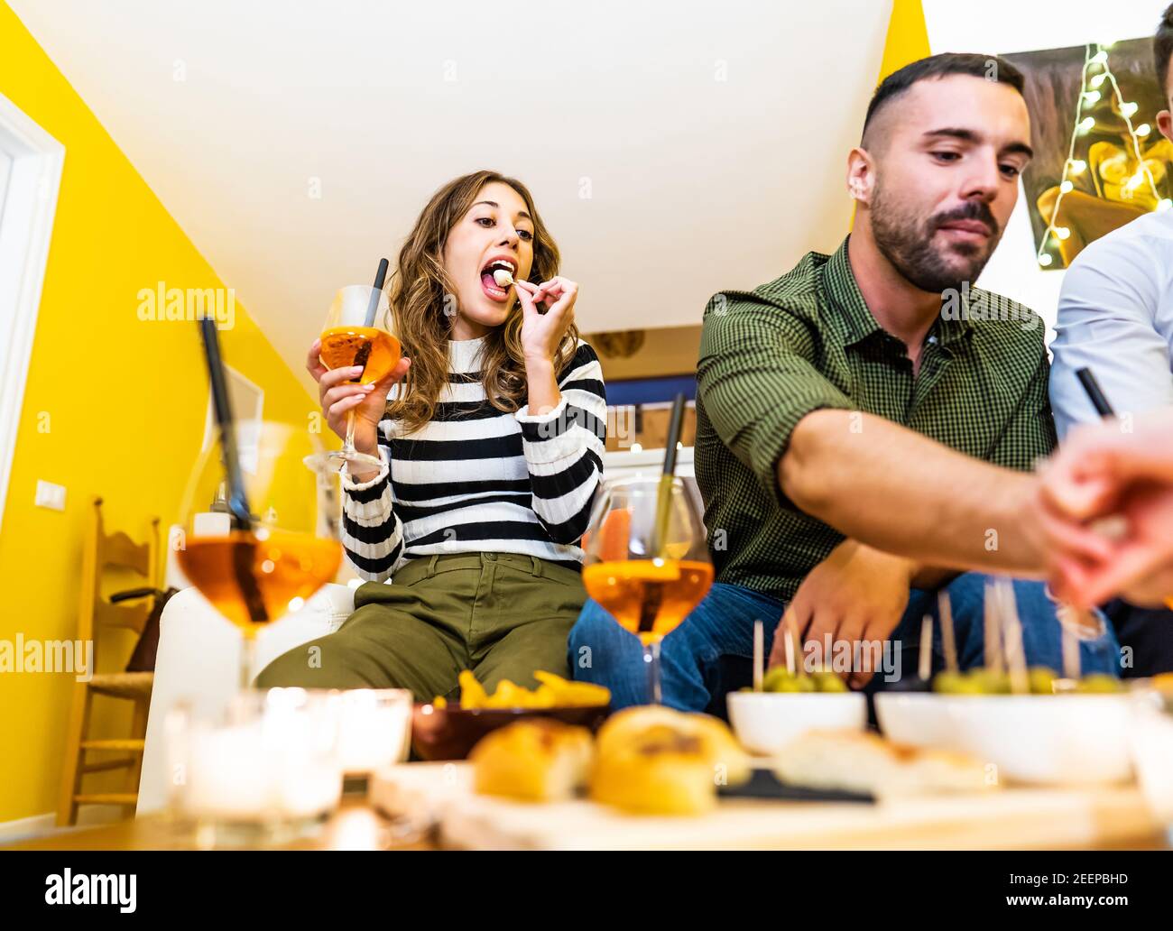 Young friends having fun at home aperitif with spritz cocktail and ...