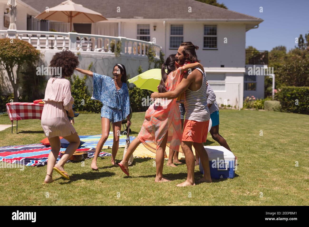 Diverse group of friends greeting each other at a pool party. Hanging ...