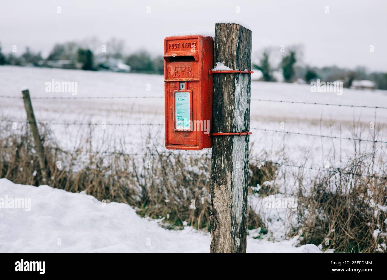 Traditional red English Postbox covered in snow in the countryside ...