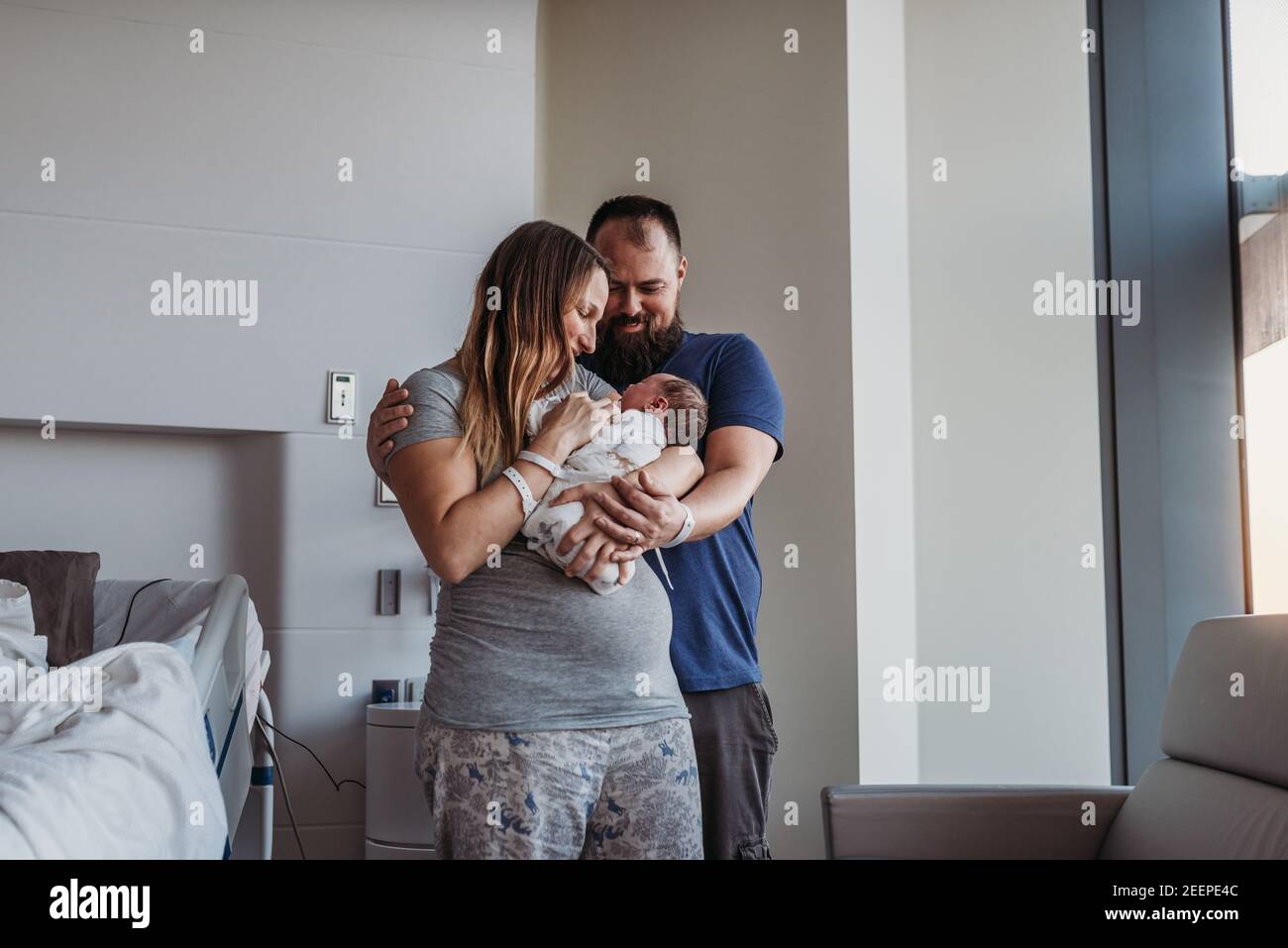 Newborn baby boy being cradled by new parents in birthing center Stock ...