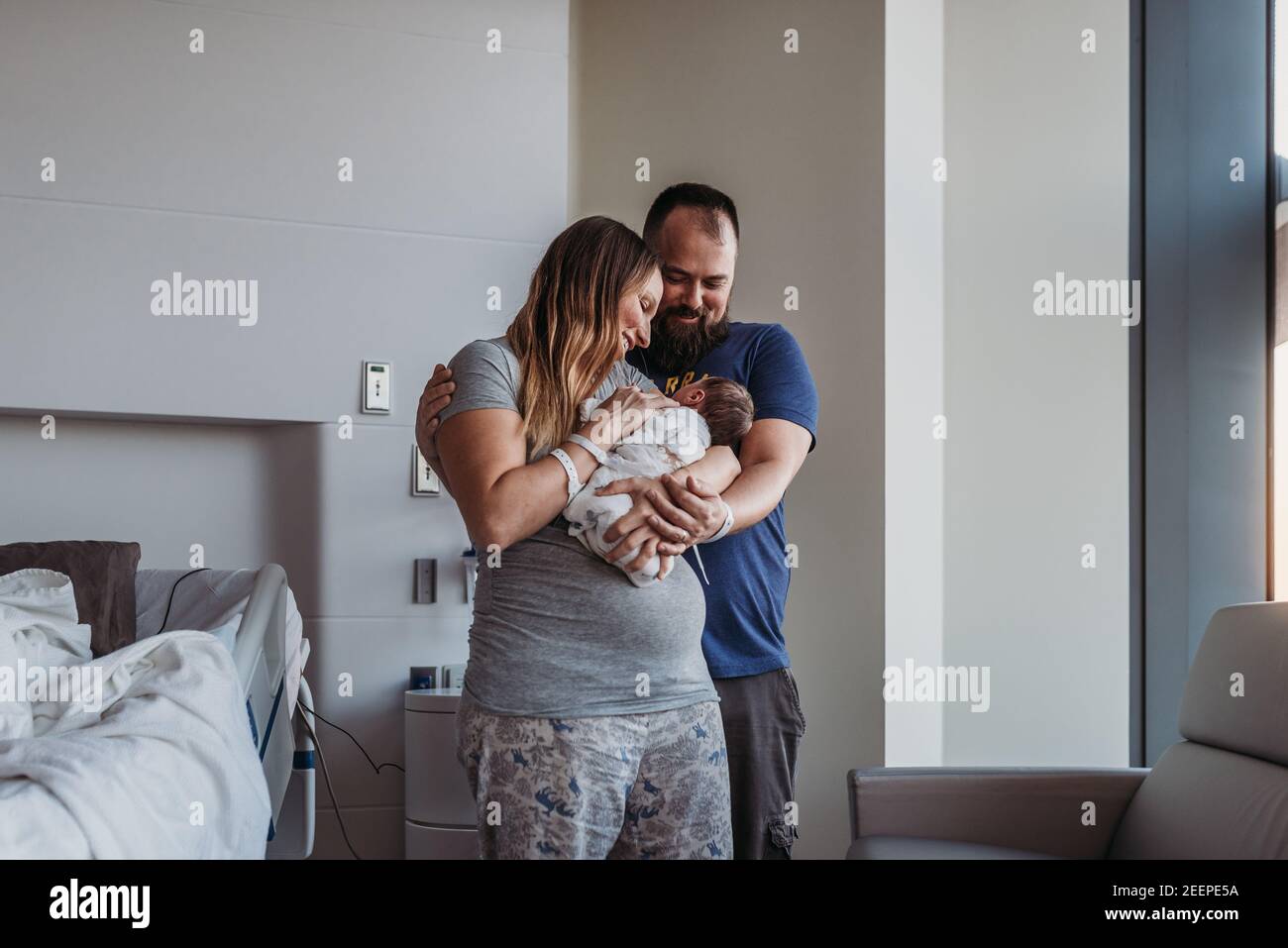 newborn baby boy being cradled by new parents in birthing center Stock ...