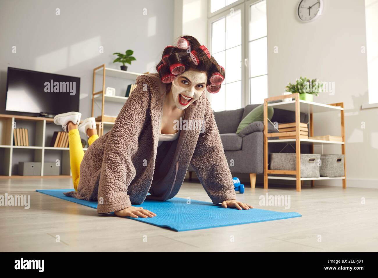 Happy young woman doing knee push-ups on exercise mat during fitness ...