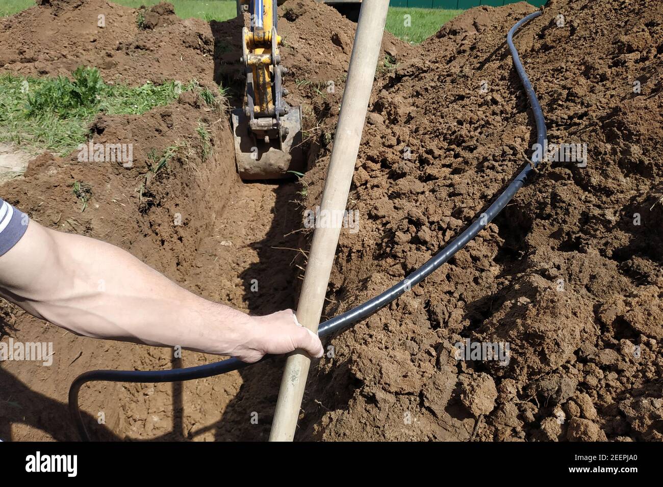 Wiring of an electric cable on the dug trench, supply of the electric ...