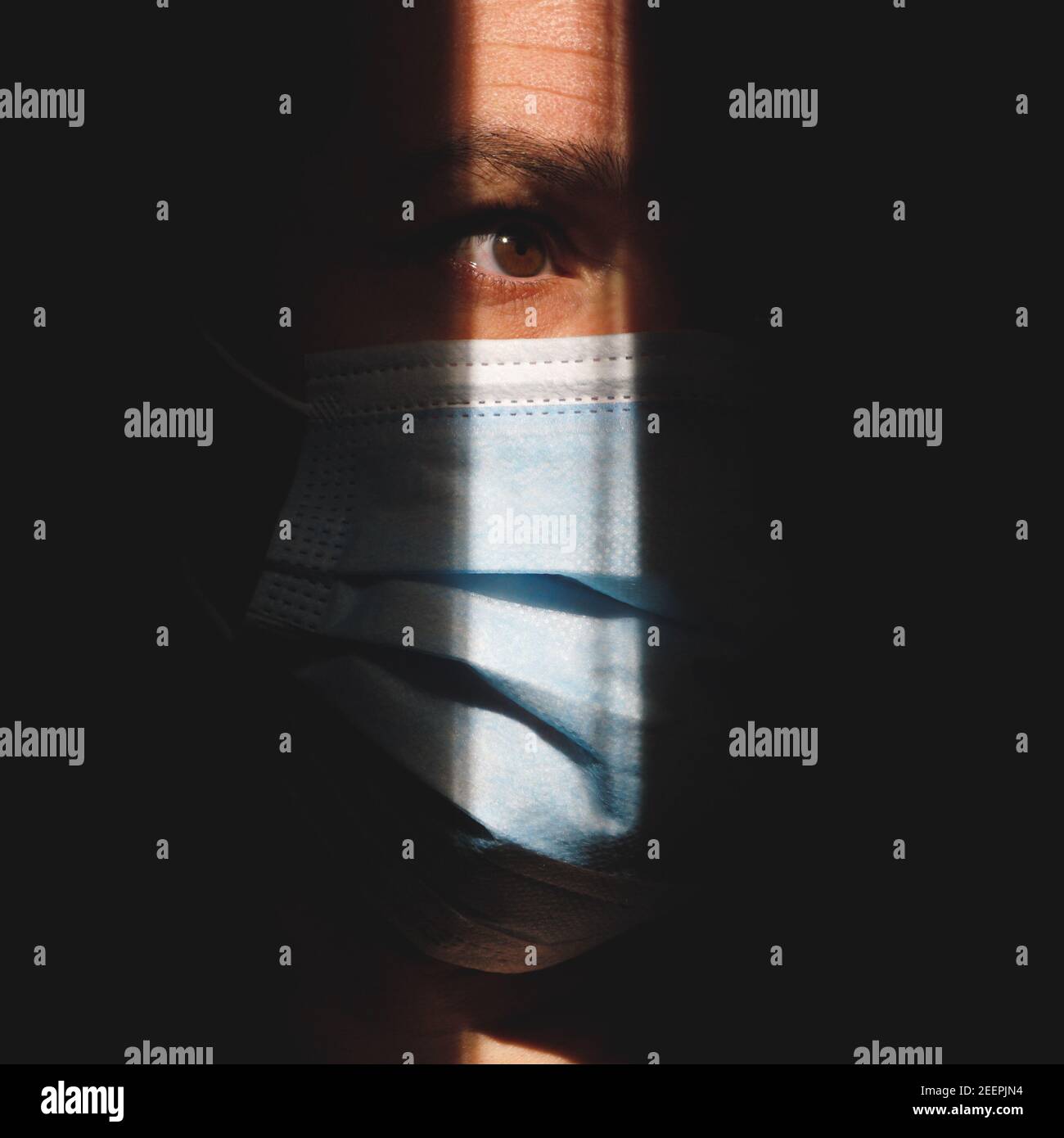 man with mask in the shadows showing the brown eye Stock Photo - Alamy