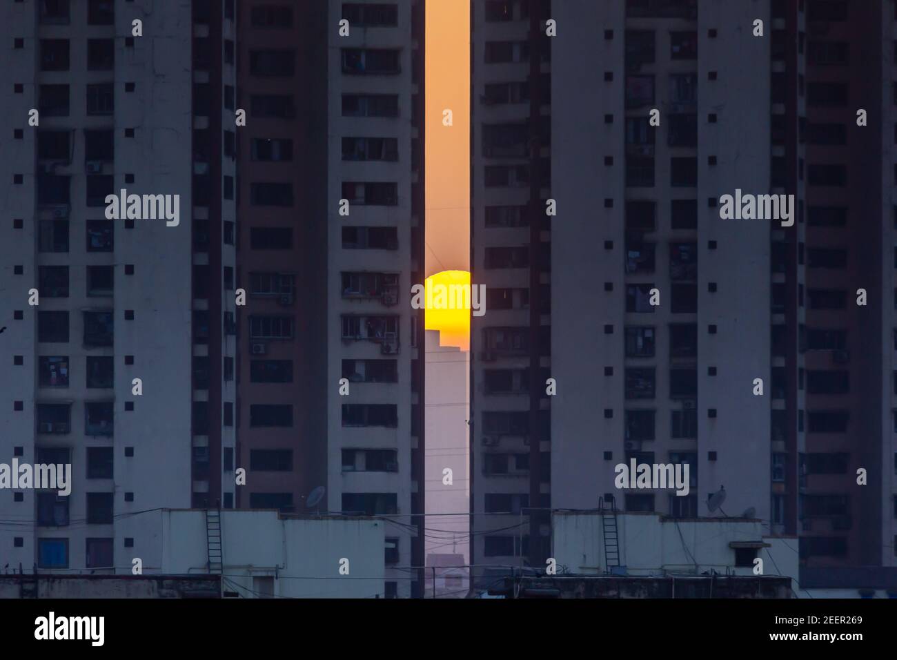 Mumbai, Maharashtra, India - March 2017: The sun sets between the tall ...