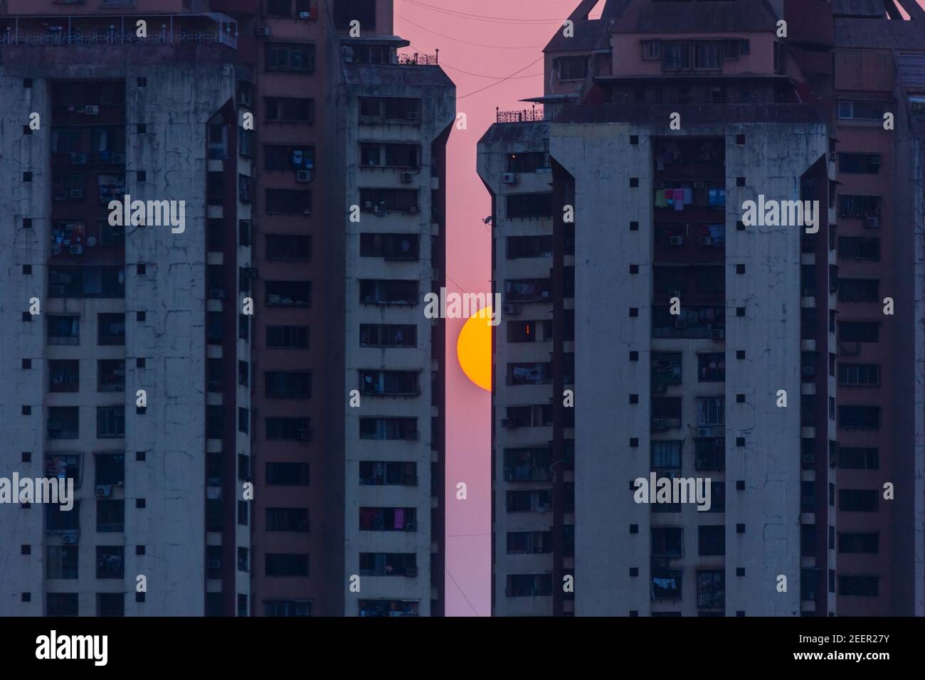 Mumbai, Maharashtra, India - March 2017: The sun sets between the tall ...