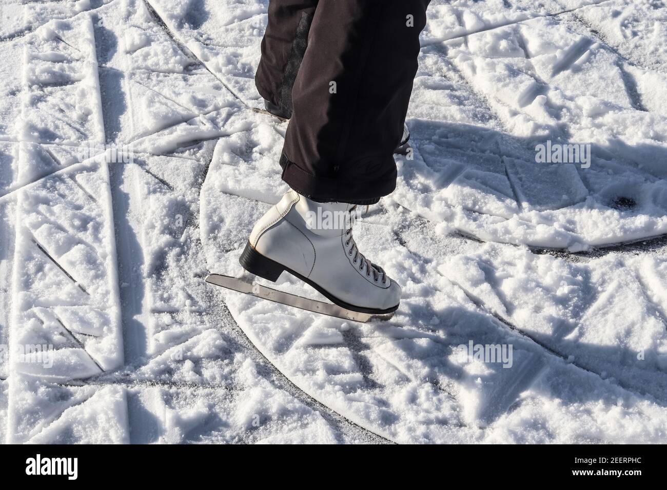 Close up on womans feet wearing ice skating boots and standing on ice ...