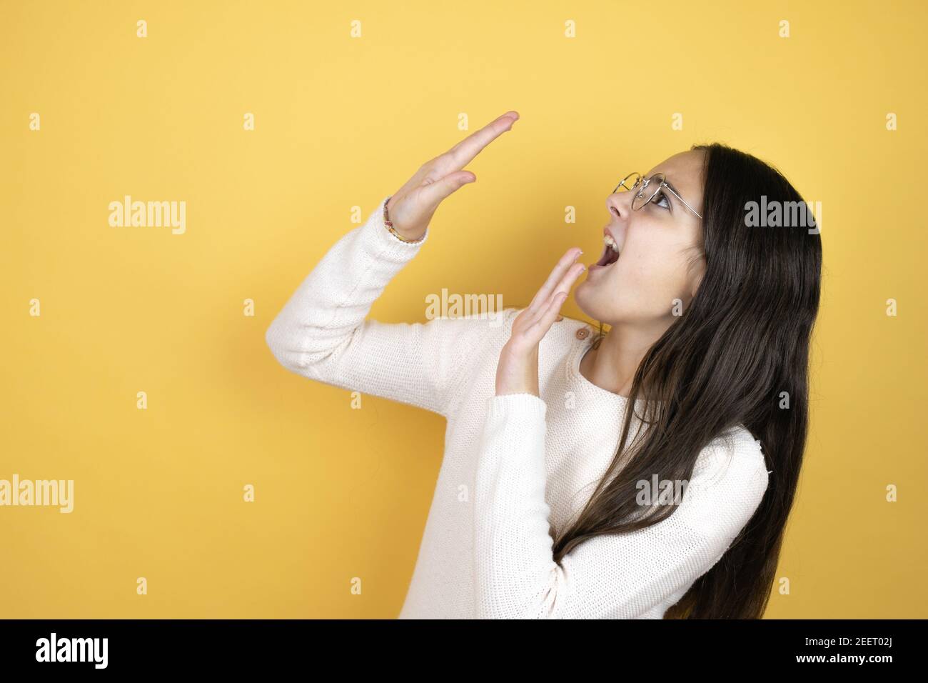 Beautiful child girl wearing casual clothes scared with her arms up ...