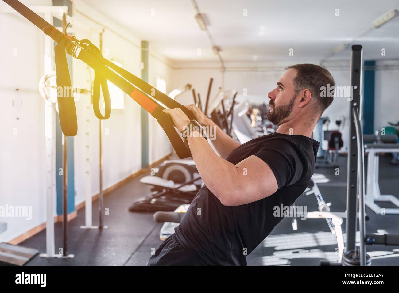Young man doing TRX exercises at the gym. TRX training Stock Photo - Alamy