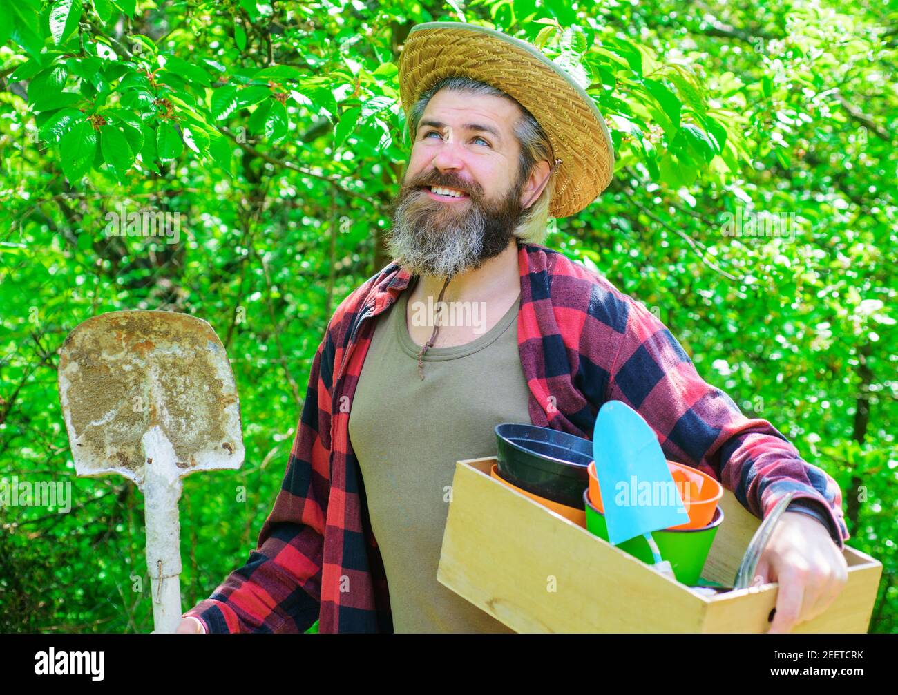 Happy farmer in spring garden. Gardener in Eco-farm with gardening ...