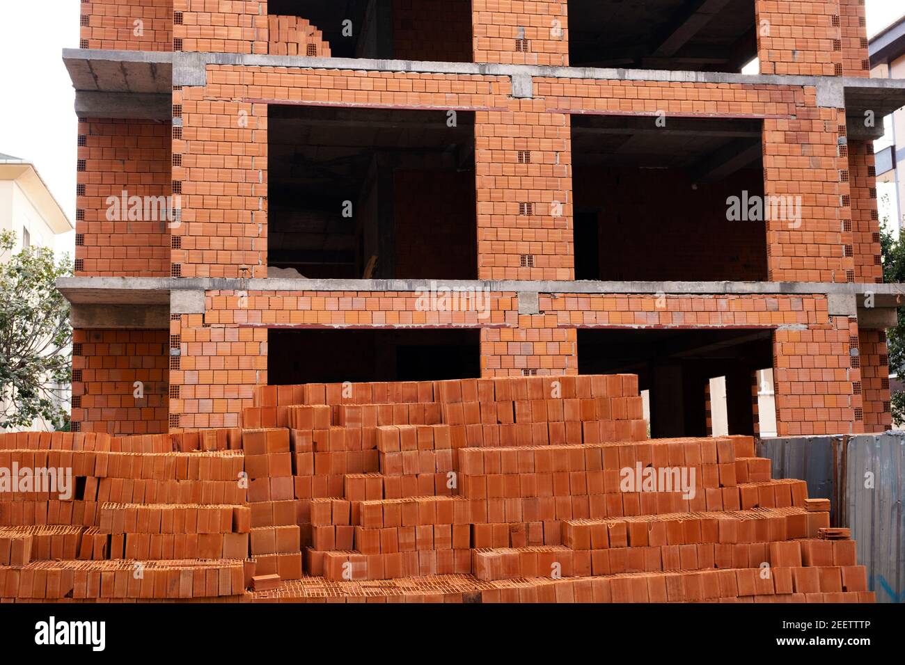 Clay brick building material and building under construction in the ...