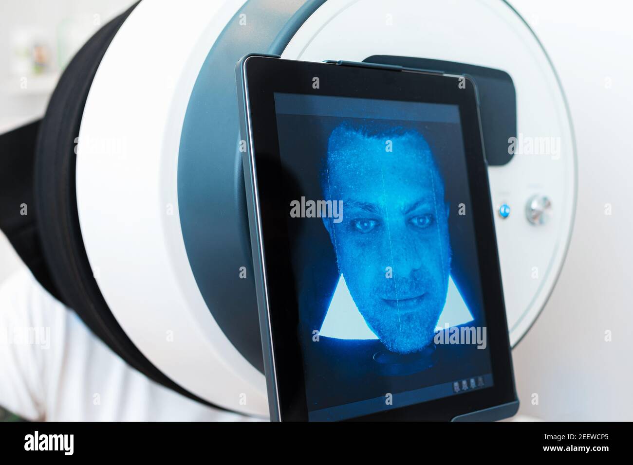 The monitor shows the condition of the skin of a man's face on modern ...