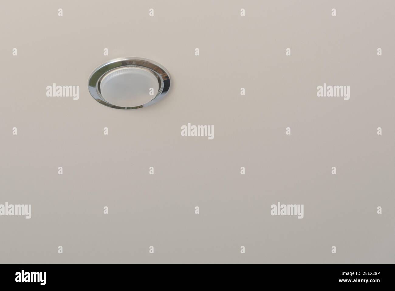 LED built-in lamp on white stretch ceiling. Chrome finish and matt ...
