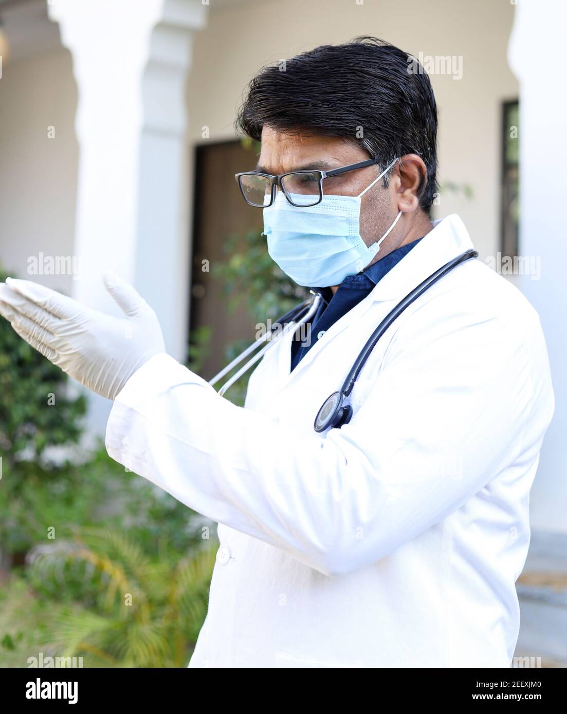 Middle-aged Indian doctor giving instructions with gestures standing ...