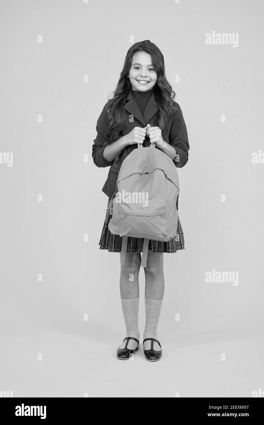 Schooling in style. Happy child hold school backpack yellow background ...