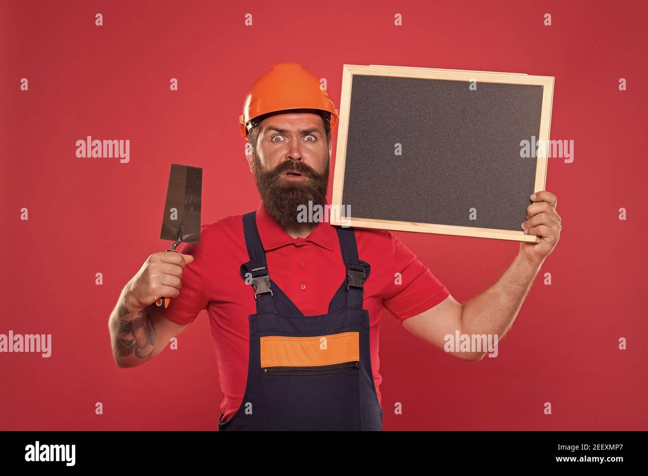 Plasterer hipster builder in hard hat hold blackboard copy space ...