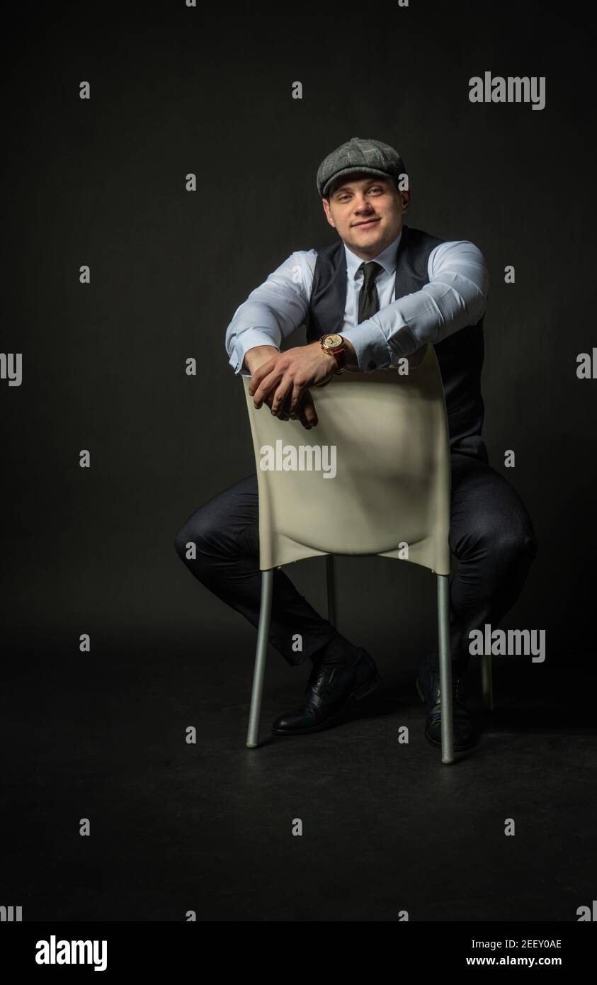 in a cap on a chair Young man three piece suit style man, lifestyle ...