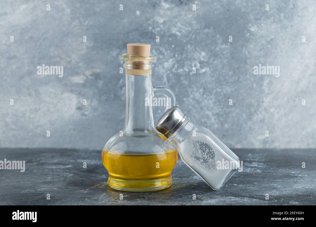 Bottle of oil and salt on grey background Stock Photo - Alamy