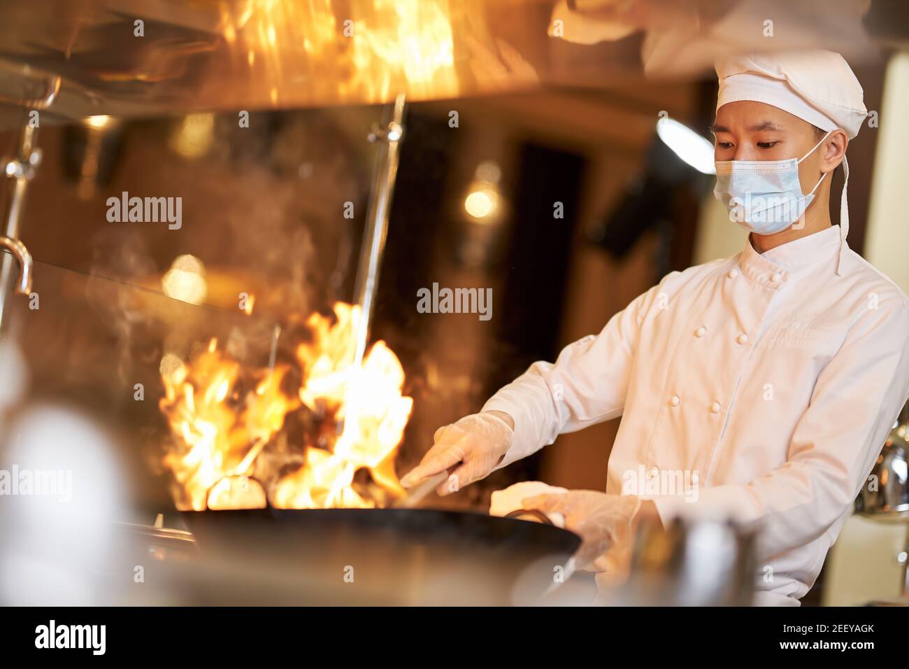 Incredible Asian chef operating a wok on fire while cooking stir-fry ...