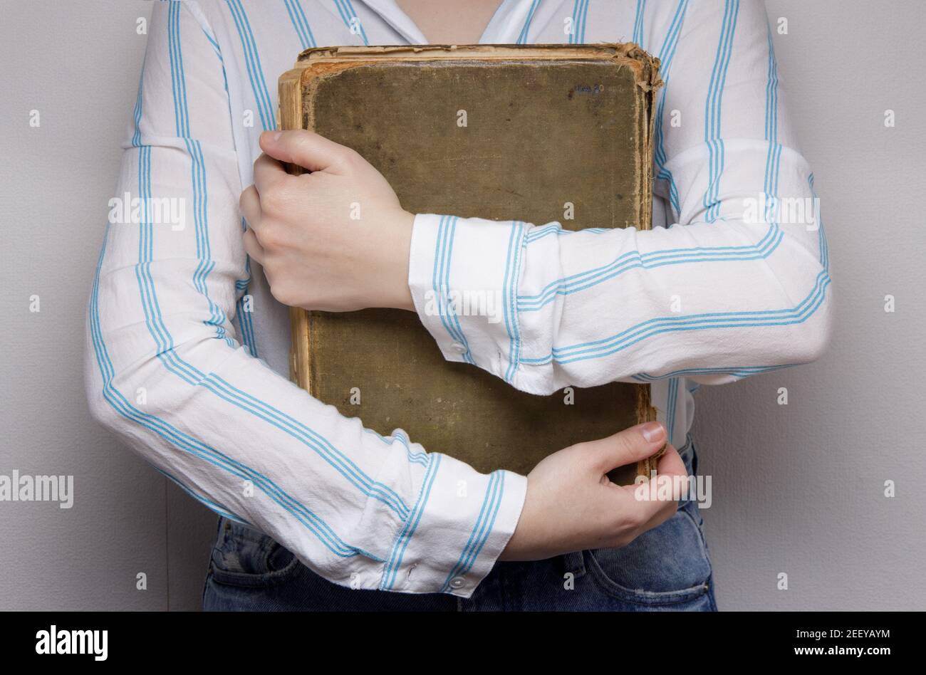 hands of an invisible person holds hugs an old book Stock Photo - Alamy