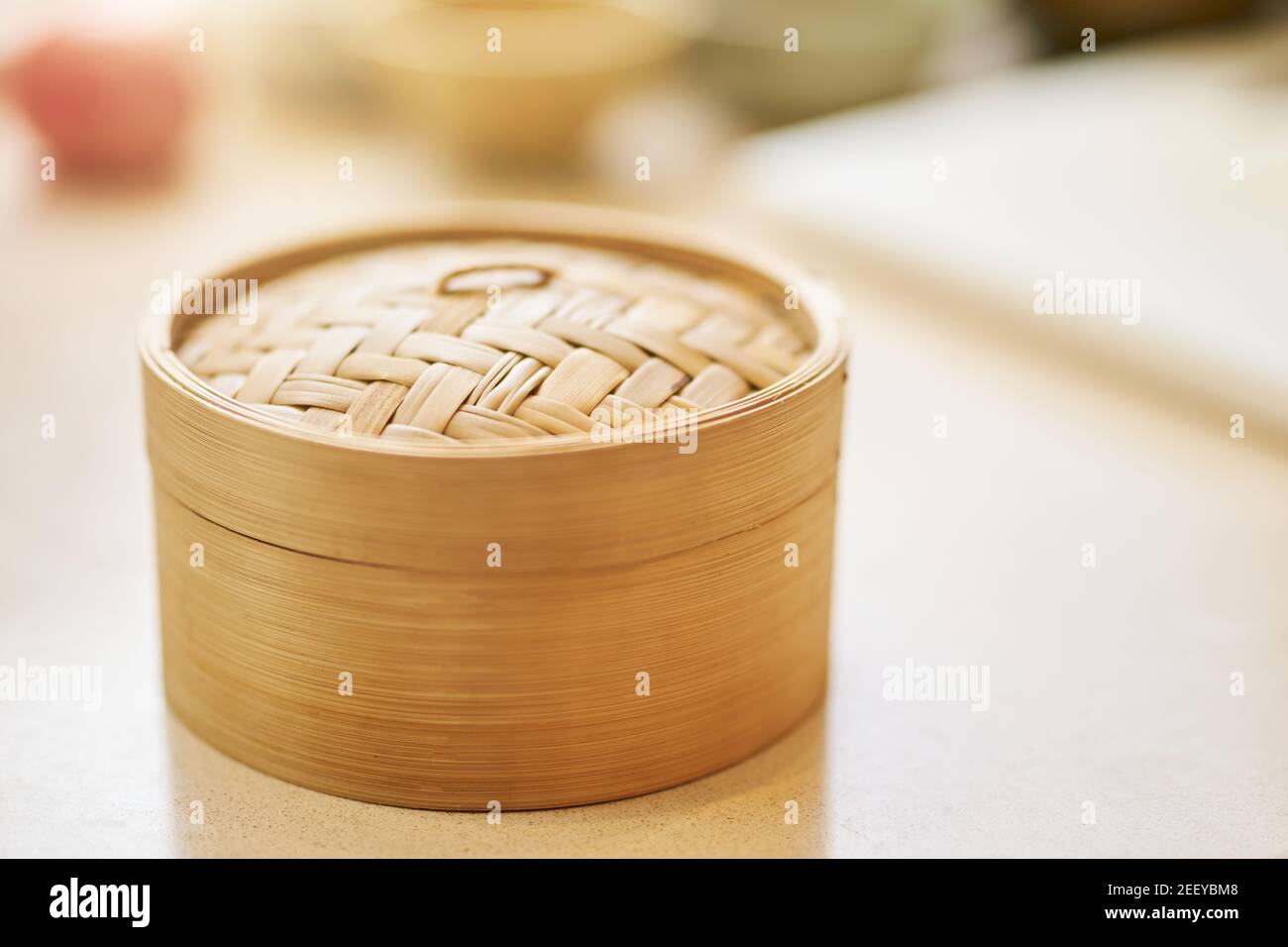 Close-up photo of a round bamboo container on a woodent table surface ...