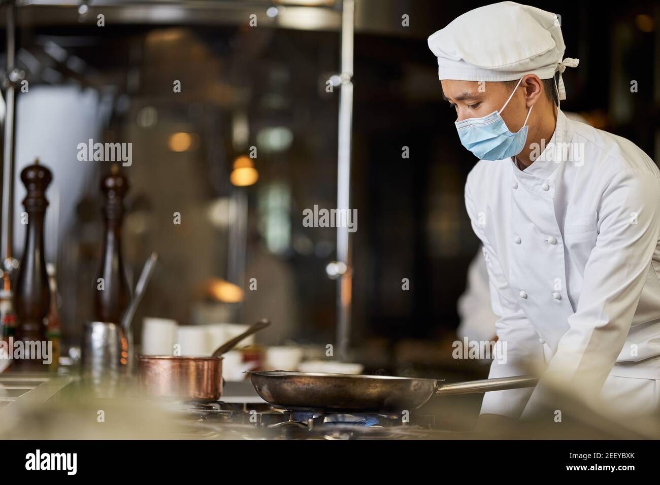 Copy-space photo of an attentive male chef watching closely over the ...