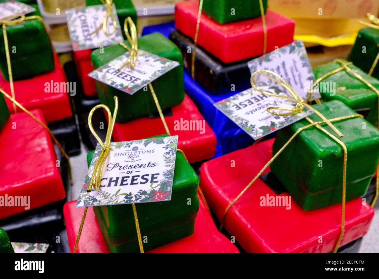 A stack of Singletons & Co artisanal cheese presents wrapped in golden ...