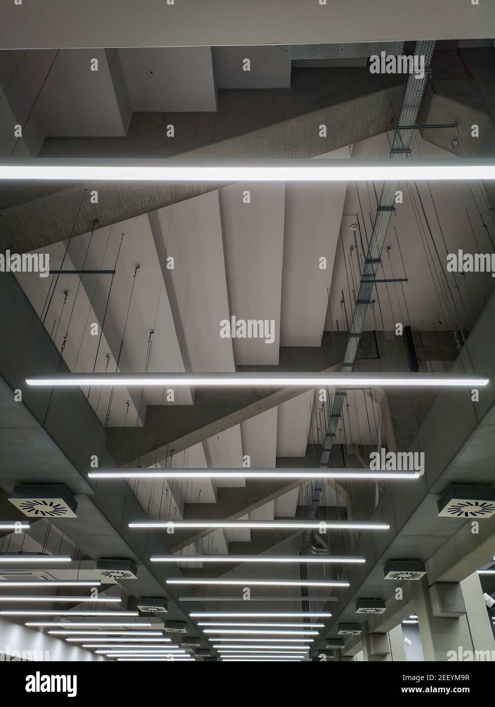 Glowing lamps hanging under ceiling and ventilation ducts Stock Photo ...